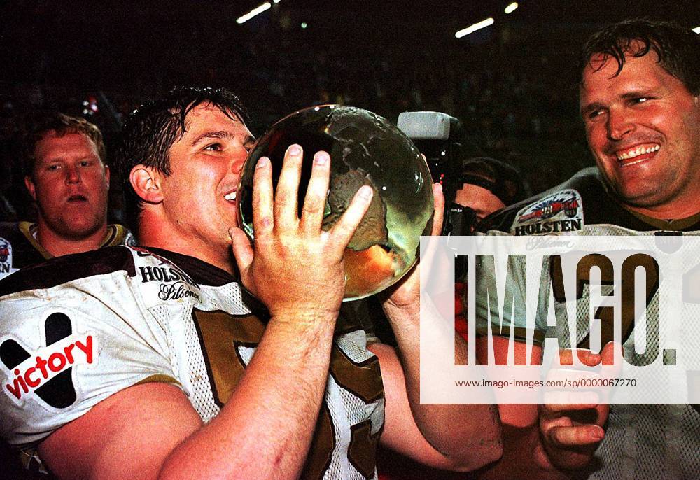 Center Bob Kronenberg mit dem Pokal, re. Tackle Derek West American ...