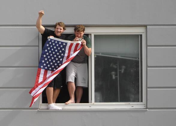 USA fans cheer on their team from a building near the 4th tee box ...