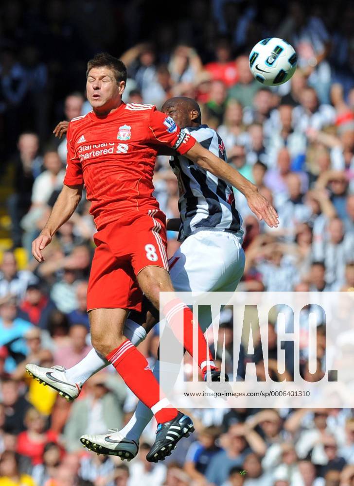 Steven Gerrard of Liverpool jumps for the ball with Youssuf Mulumbu of ...