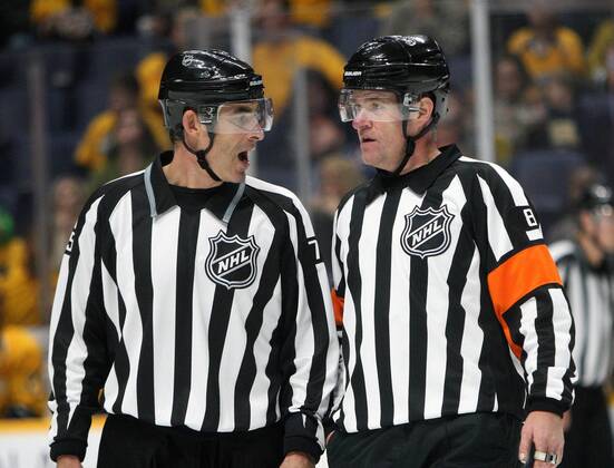 : Referee Dave Jackson and linesman Derek Amell talk during the NHL ...