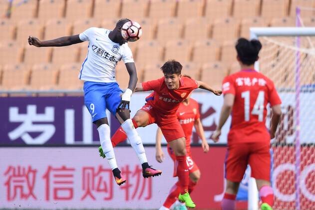 Nigerian football player Brown Ideye of Tianjin TEDA, center, kicks the ...