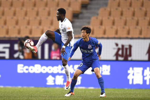 Nigerian football player Brown Ideye, left, of Tianjin TEDA heads the ...