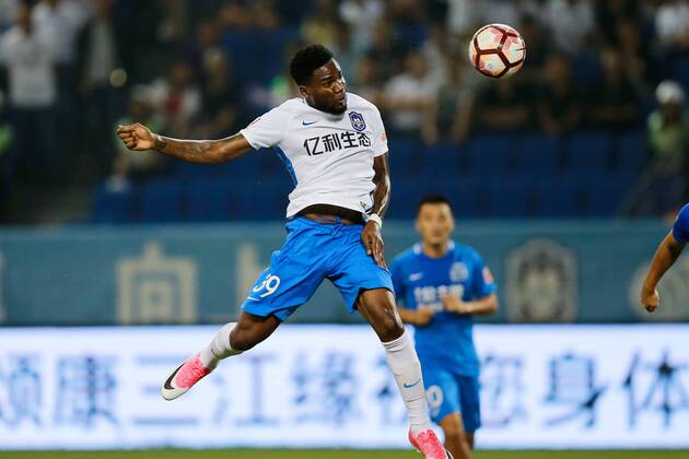 Nigerian football player Brown Ideye of Tianjin TEDA, center, kicks the ...