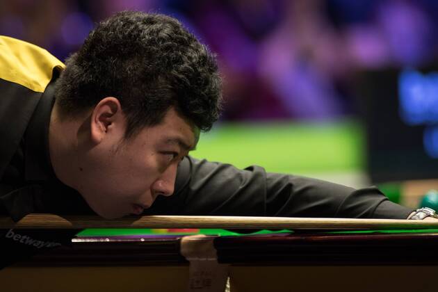 Li Hang of China plays a shot to Ryan Day of Wales in their fourth ...