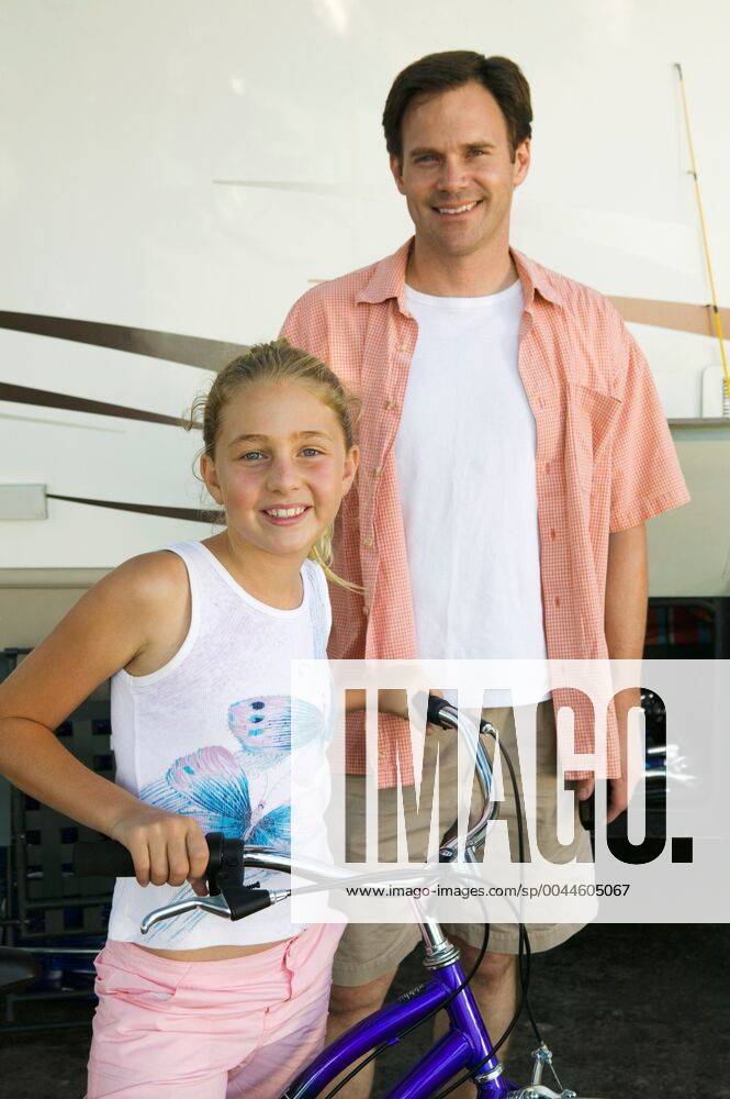 Father with Daughter on Bike Next to RV