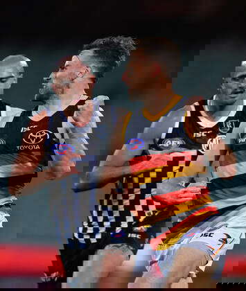 AFL POWER CROWS, Brodie Smith of the Crows has his kick smothered by ...