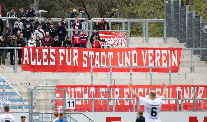 v li Fans of FC Würzburger Kickers behind a banner with the inscription ...