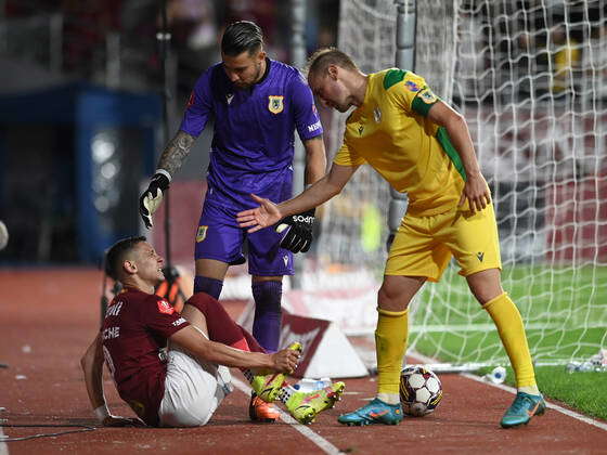 Alin Iustin Popescu and Manuel Adrian Scarlatache help Valentin Ionut Costache stand up in the