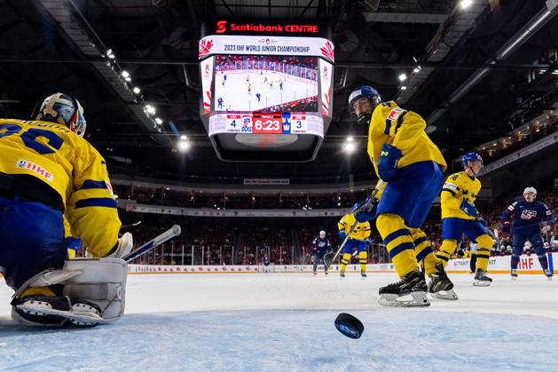 Goaltender Carl Lindbom and Axel Sandin Pellikka of Sweden look ...