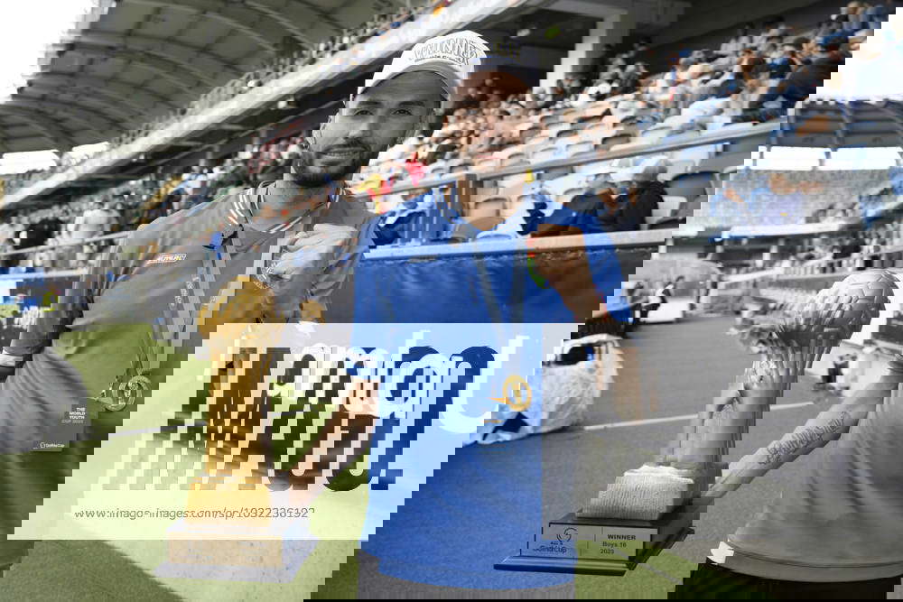 An ED Moratalaz coach poses with the trophy after winning the B16 class ...