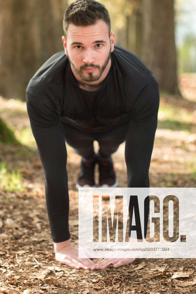 Photo of handsome nice guy outdoors at morning. Young man doing push up ...