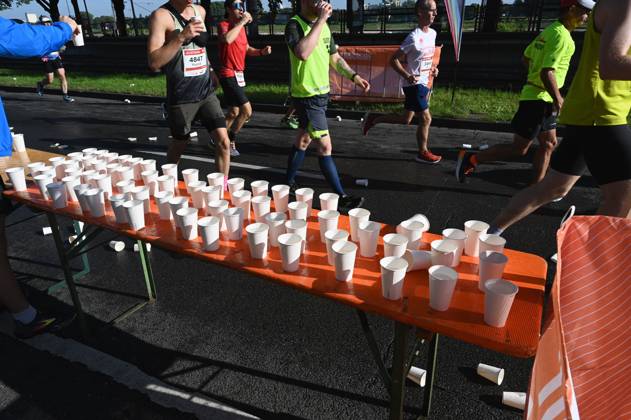 Refreshment stand handing out cups with water Runners on the course of ...
