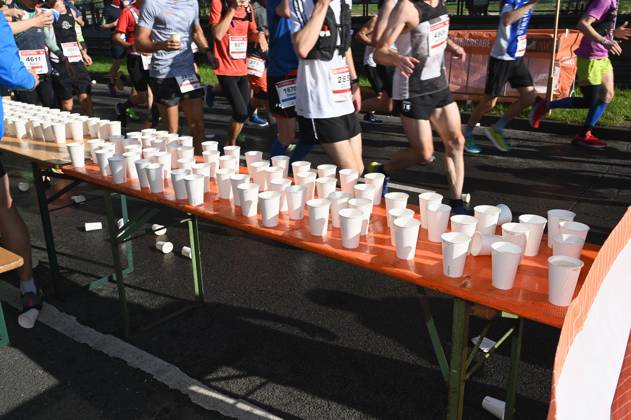 Refreshment stand handing out cups with water Runners on the course of ...