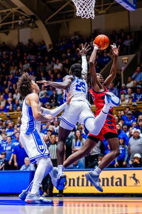 : Duke Blue Devils Mark Mitchell guards the shot from Souther Indiana ...