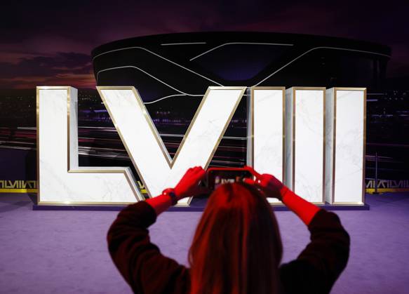 Fans take photos of the Super Bowl roman numerals at the opening of the ...