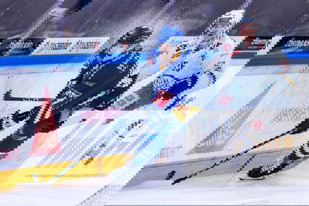 Mirco Müller 25 HC Lugano looks after Fabrice Herzog 68 EV Zug during ...