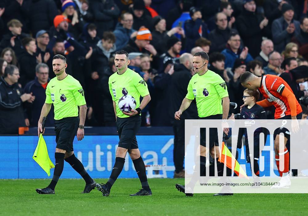 Referee Michael Oliver walks with assistants Stuart Burt and Dan Cook ...