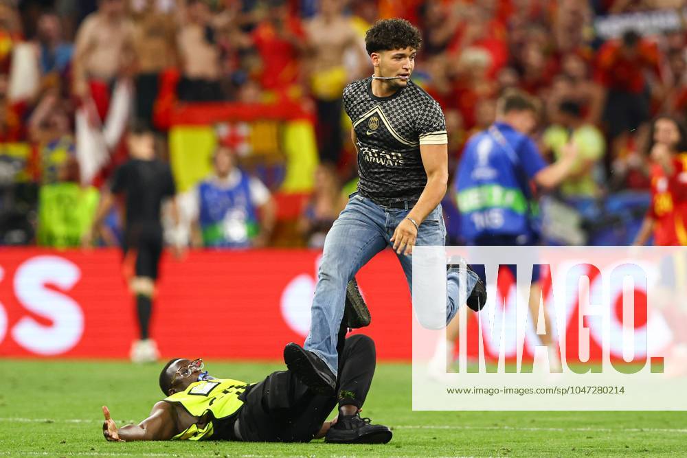 A pitch invader is tackled by security at full-time Spain v France ...