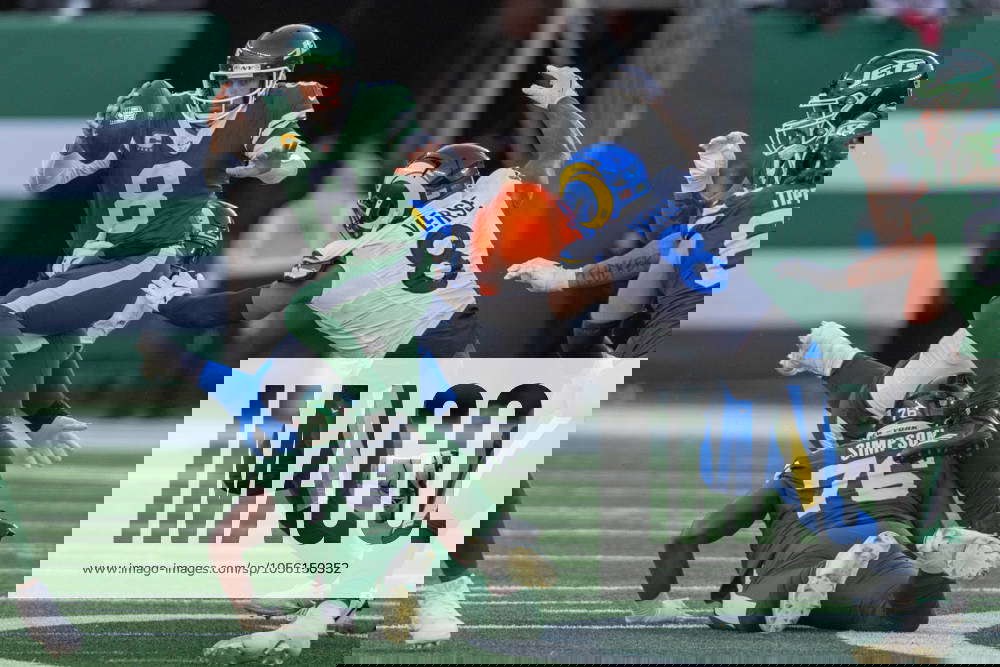 New York Jets quarterback Aaron Rodgers (8) leaps over offensive ...