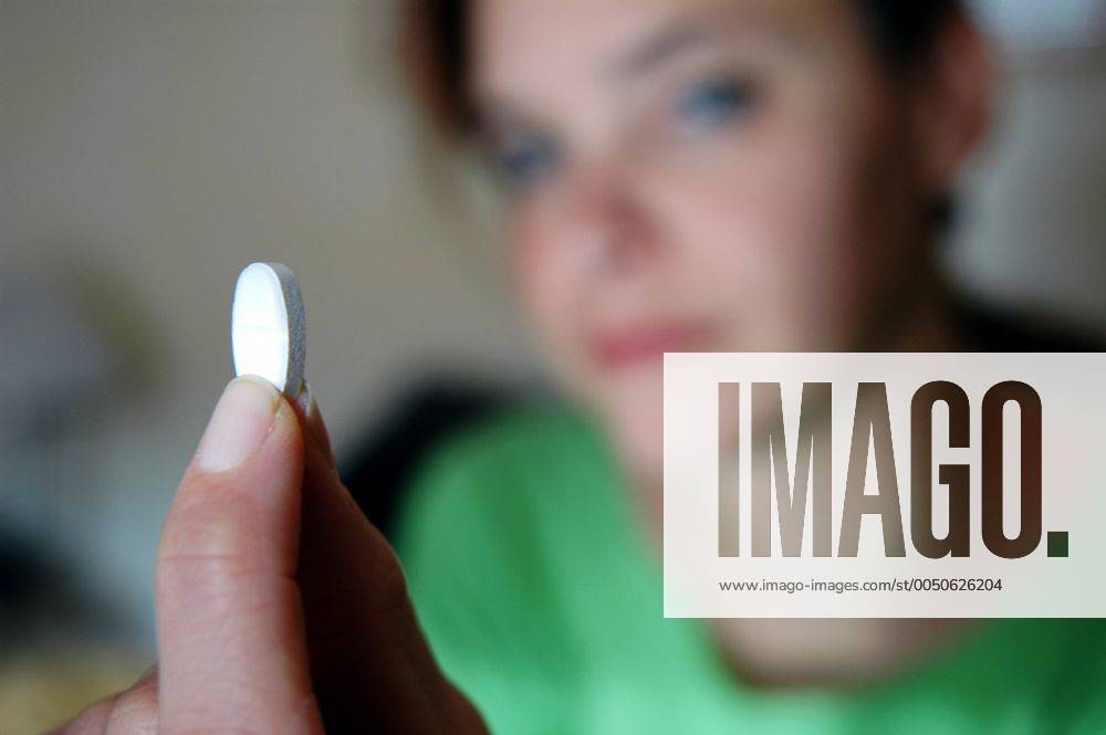 Medikamenteneinnahme - Kranke hält eine Tablette zwischen den