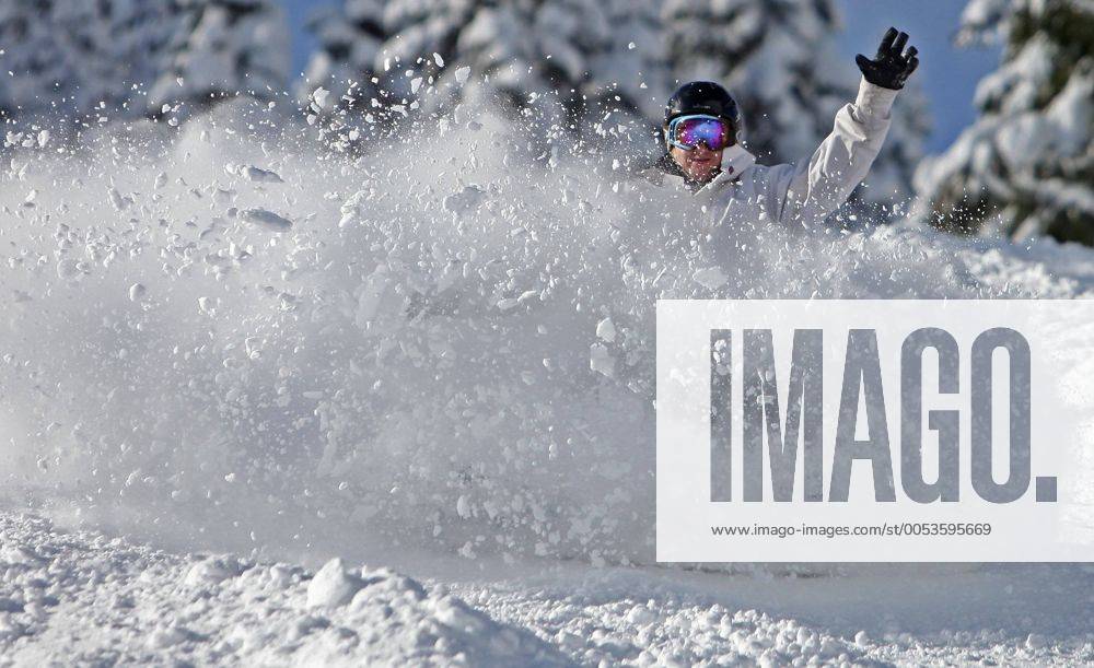 A snowboarder comes to an abrupt stop, showering light snow in his wake ...