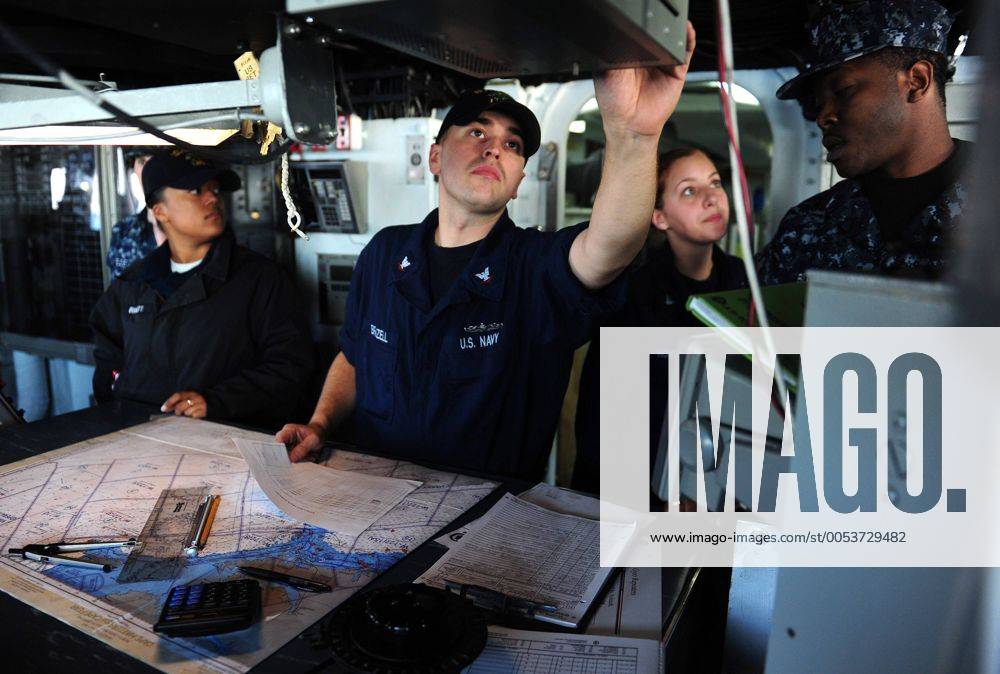 E4Qm3 Robert Brazell, joined by crew members, works on the bridge of ...