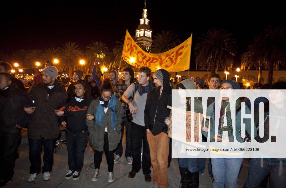 Demonstrators lock arms and stand in a wall to confront police ...