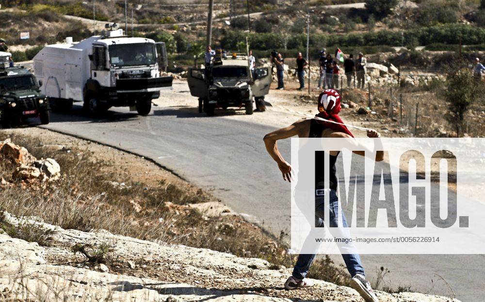 WEST BANK, Oct. 28, 2011 A Palestinian demonstrator throws stones at ...