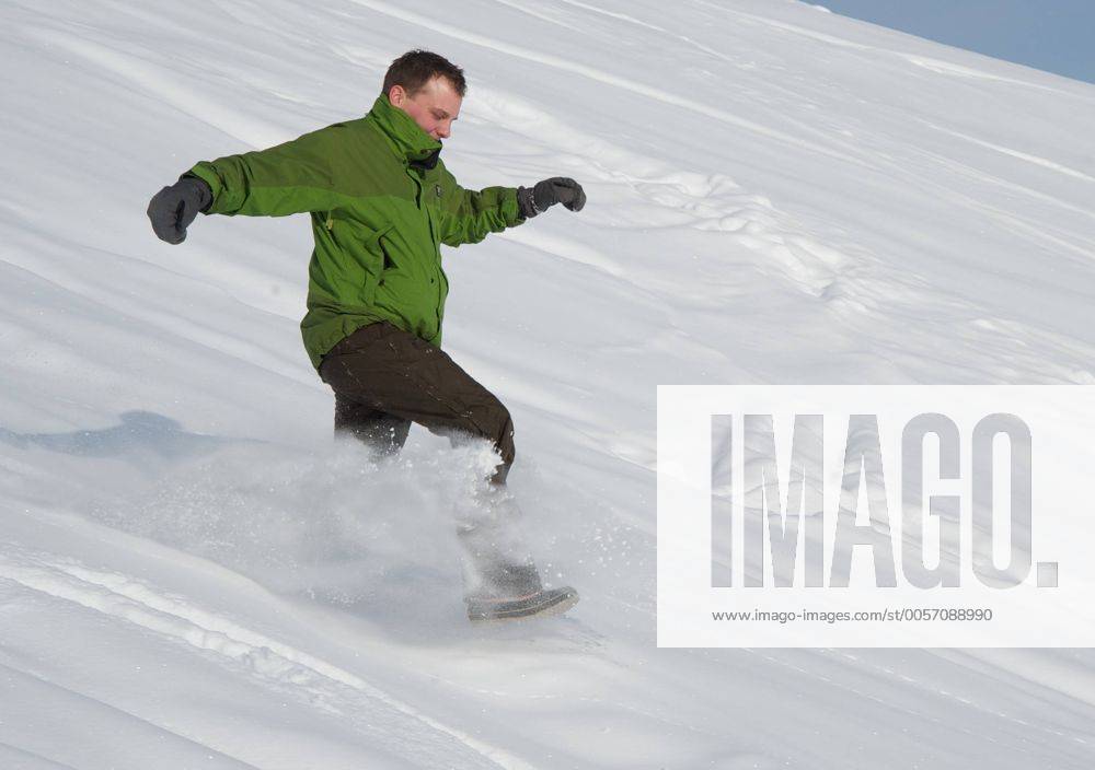 Ein Mann model released) beim Lauf durch den tiefen Schnee unterhalb ...