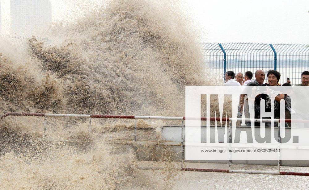 HANGZHOU, Sept. 21, 2013 People dodge the surging tide on the bank of ...