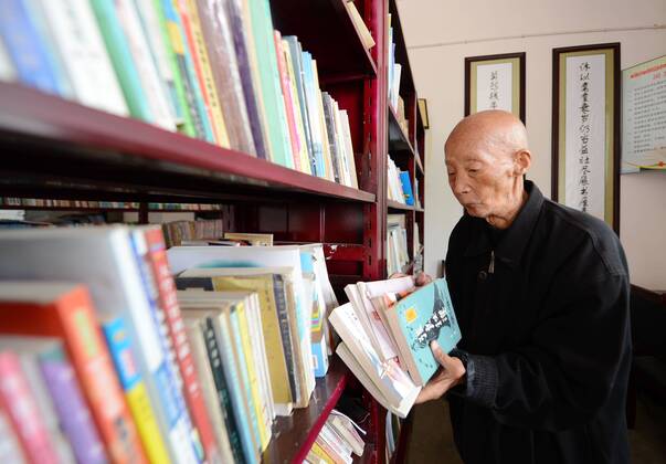 NANCHANG, Chen Renyuan arranges books at his library in Sanlian Village ...