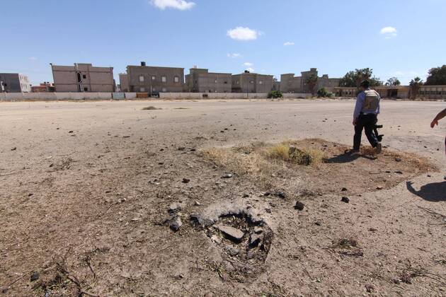 -- BENGHAZI, -- A soldier of the February 17 Brigade picks remains of their camp in Benghazi