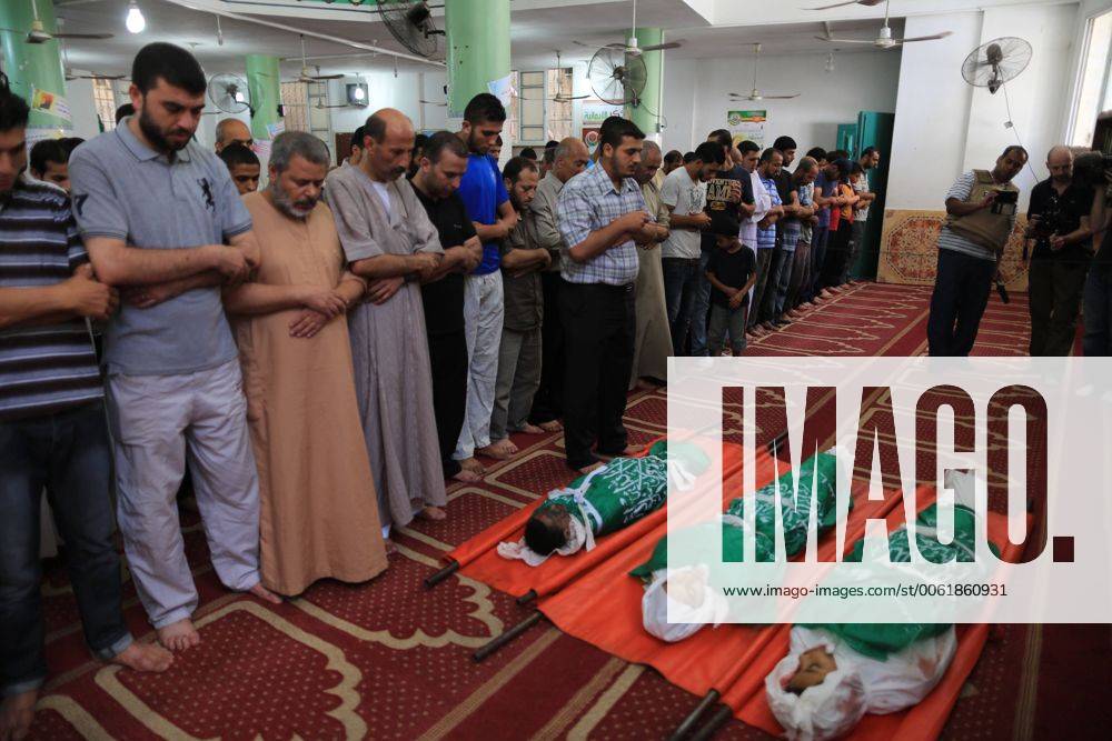 GAZA, July 18, 2014 (Xinhua) -- People pray over the bodies of three ...