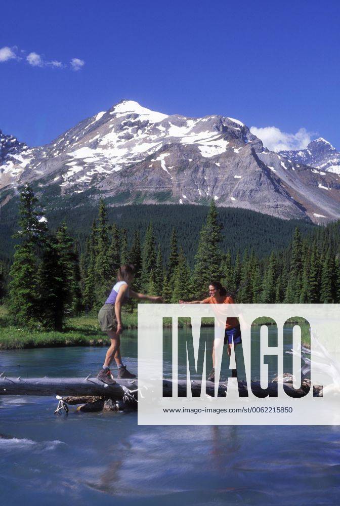 Woman helping another across Eremite Creek, Tonquin Valley, Jasper ...