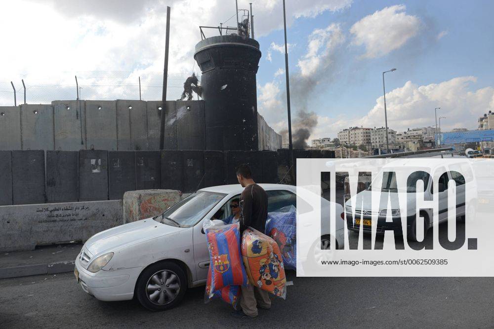 A Palestinian vendor sells pillows in front of the Israeli military ...