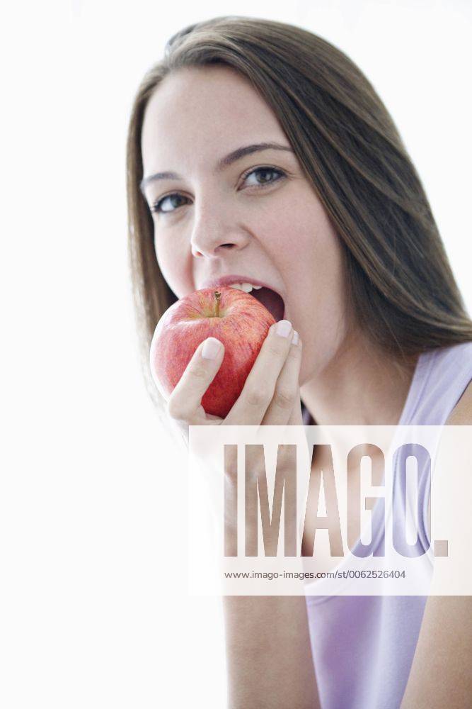 Young woman biting apple, portrait, close-up model released property ...