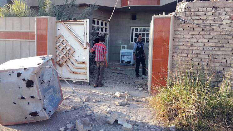 FALLUJAH, People stand by a damaged house after Iraqi Air Force bombing ...