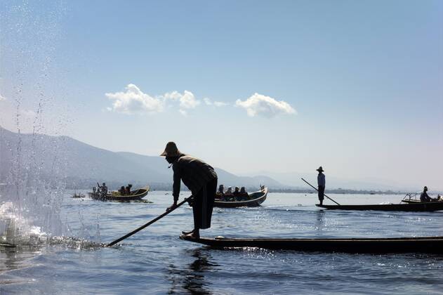 Myanmar, Shan, Lake Inle. Fisherman beating the water to attract fish ...