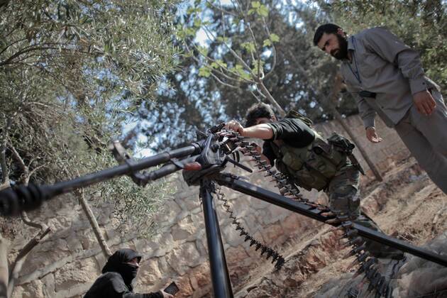 Aleppo, Syria - A Free Syrian Army fighter fires his heavy weapon ...