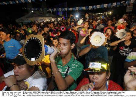 December 31, 2013 - Davao, Philippines - Filipinos simultaneously blow ...