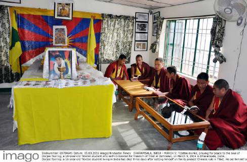 DHARAMSALA, INDIA - MARCH 5: Tibetan monks, praying for peace to the soul of Dorjee Tsering, a