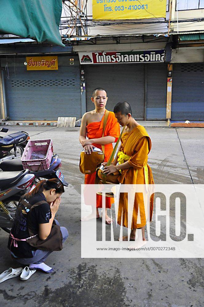 Aug. 13, 2011 - Chiang Mai, Thailand - A woman receives a morning blessing from wandering Buddhist