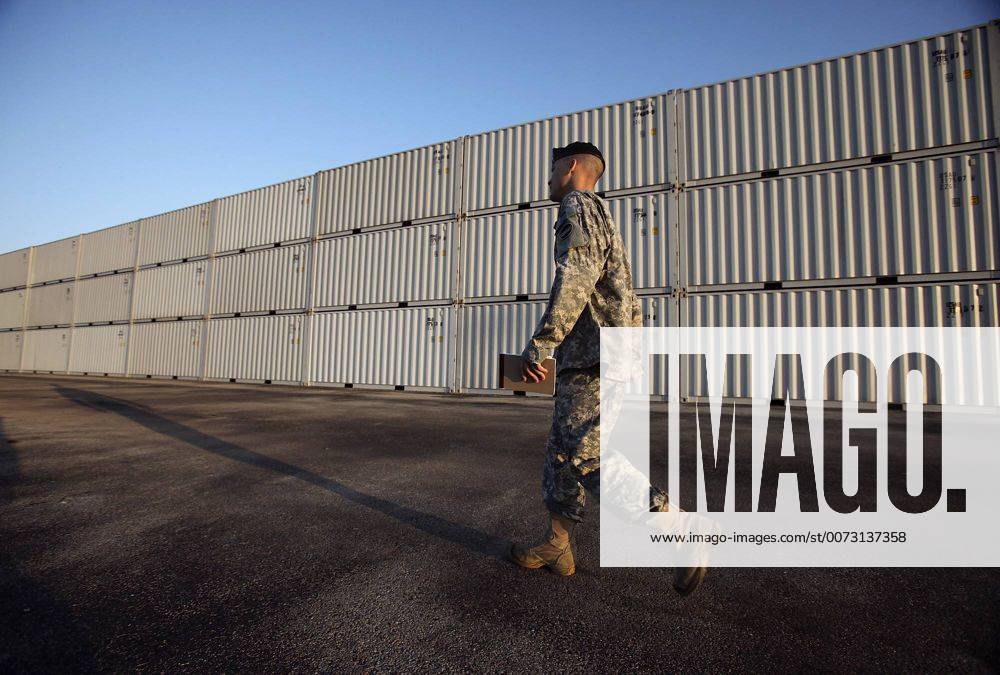 FOR METRO - A U.S. Army soldier walks past a wall of shipping ...