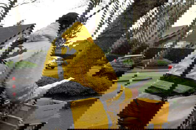 Postzusteller unterwegs Zusteller der Deutschen Post, der mit dem ...