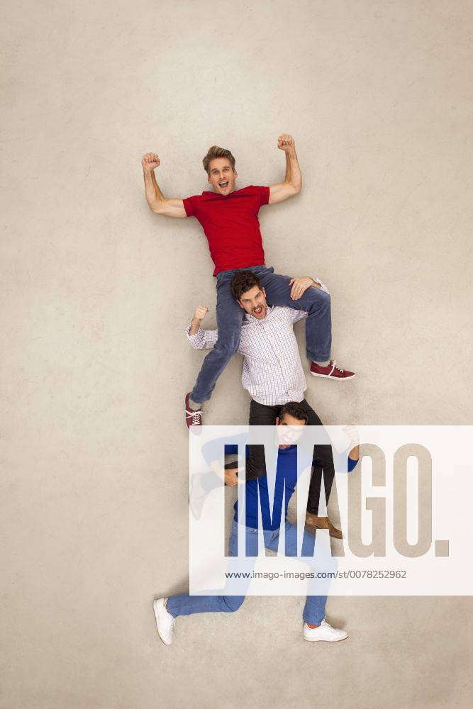 Three friends balancing on top of each other model released Symbolfoto