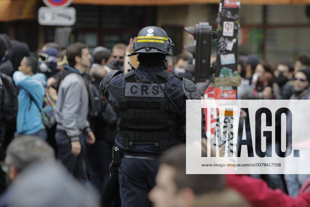 A riot police officer watches the march from the side. Thousands of ...