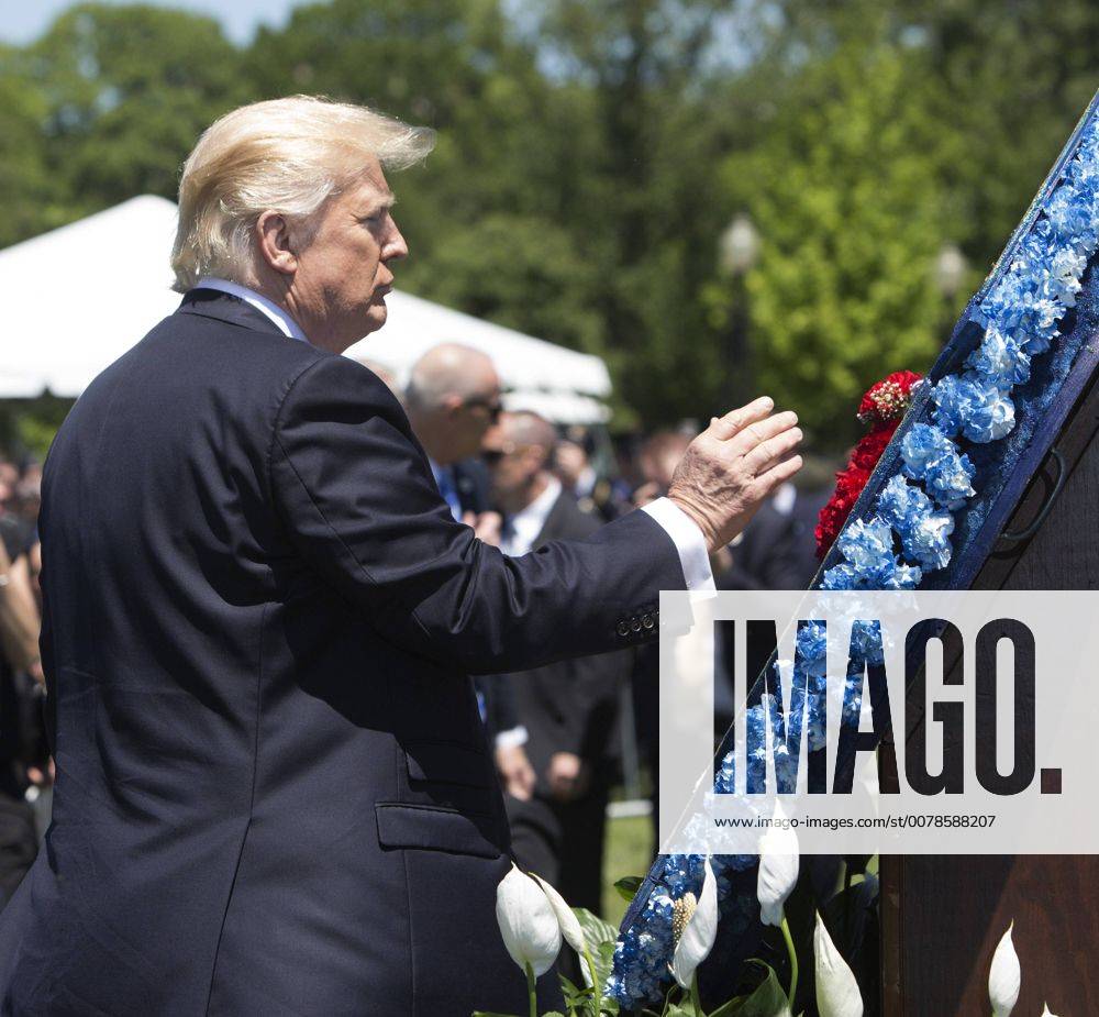 U.S. President Donald J. Trump places a flower on a memorial wreath at ...
