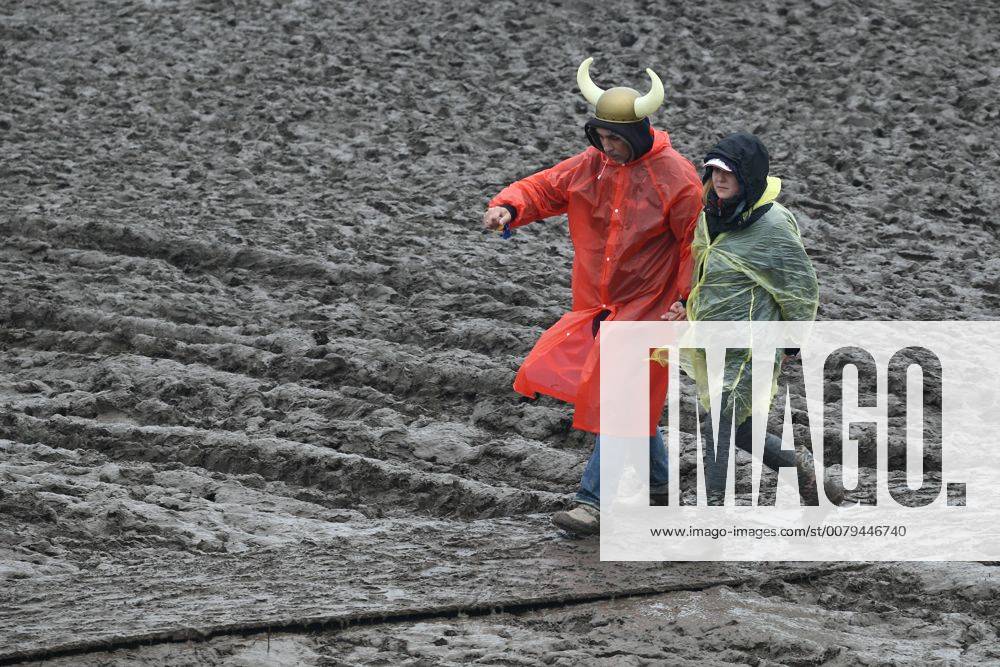 TVER REGION, RUSSIA – : People wearing raincoats and rubber boots walk ...