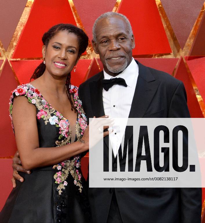 Actor Danny Glover L and Eliane Cavalleiro arrive on the red carpet for the 90th annual