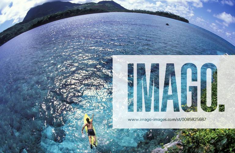 Mark Anders surfing paddeling in the aqua blue warm water off the coast ...